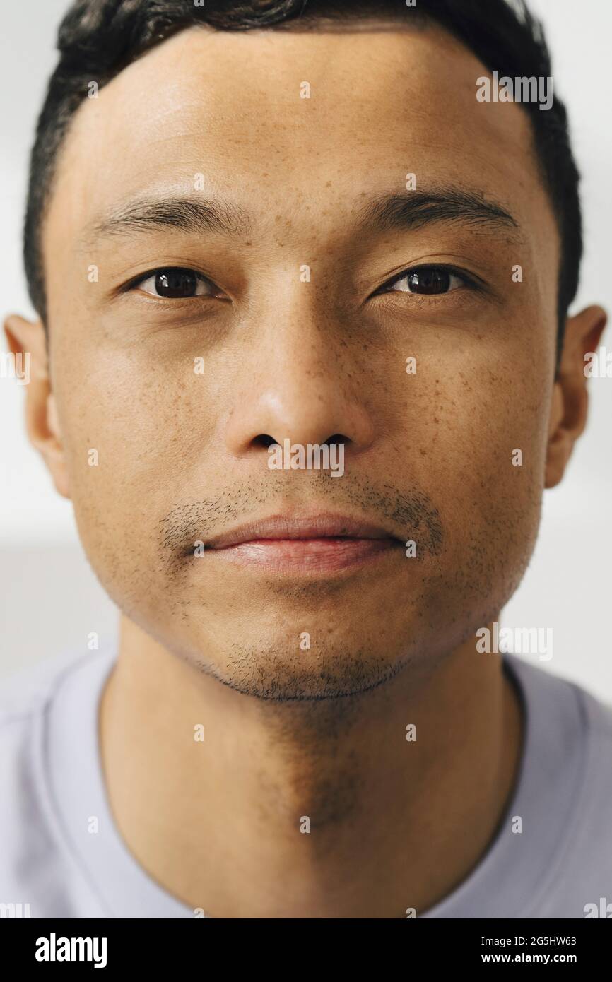 Portrait of man with hair stubble against white wall Stock Photo - Alamy