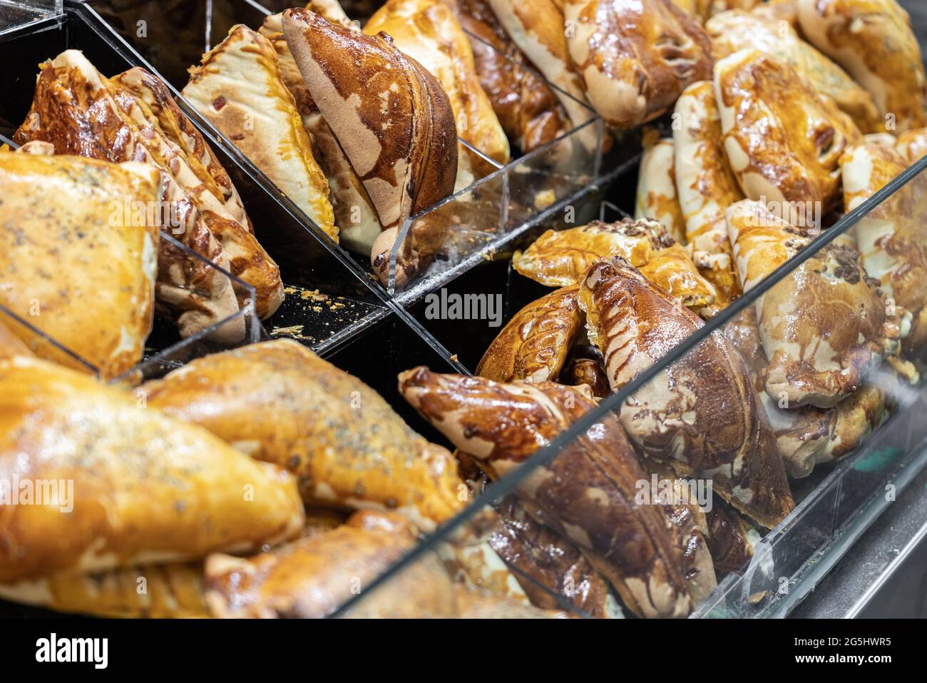 Empanada is a baked or fried pastry and meat, cheese, tomato, corn, or ...