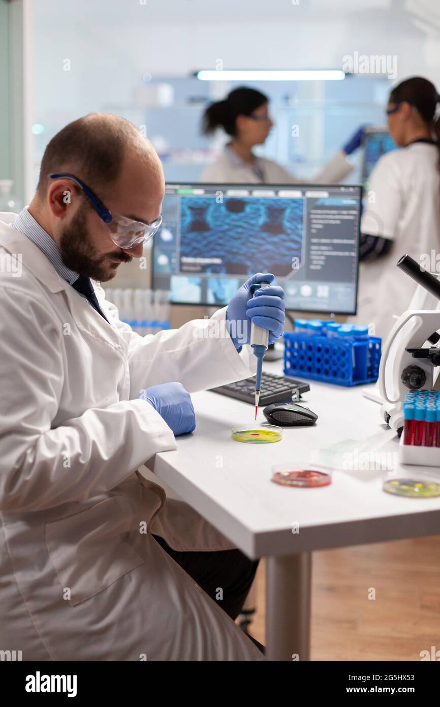 Scientist doing genetic experiment using blood sample on micropipette ...