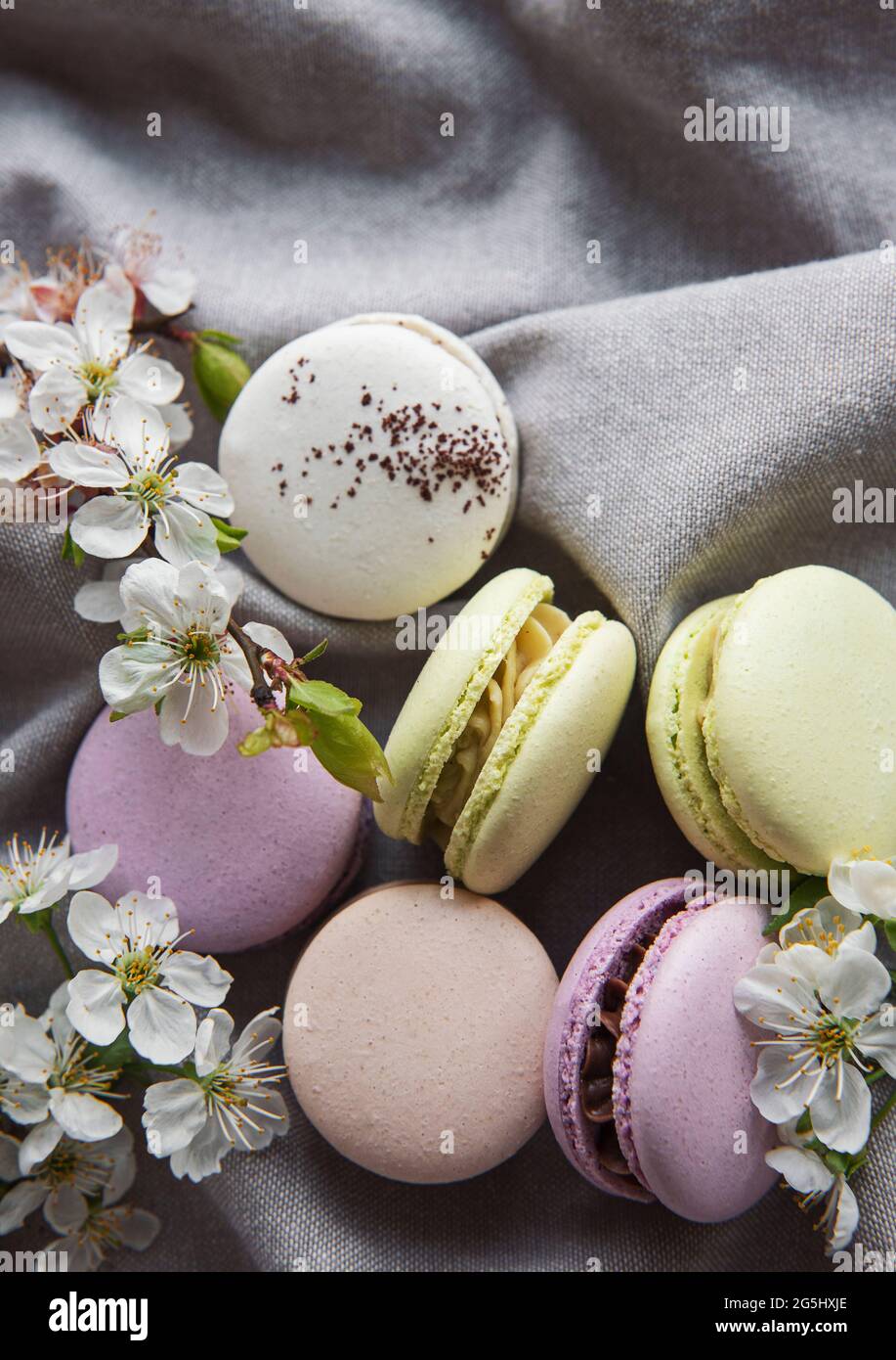 French sweet macaroons colorful variety on a gray textile background ...