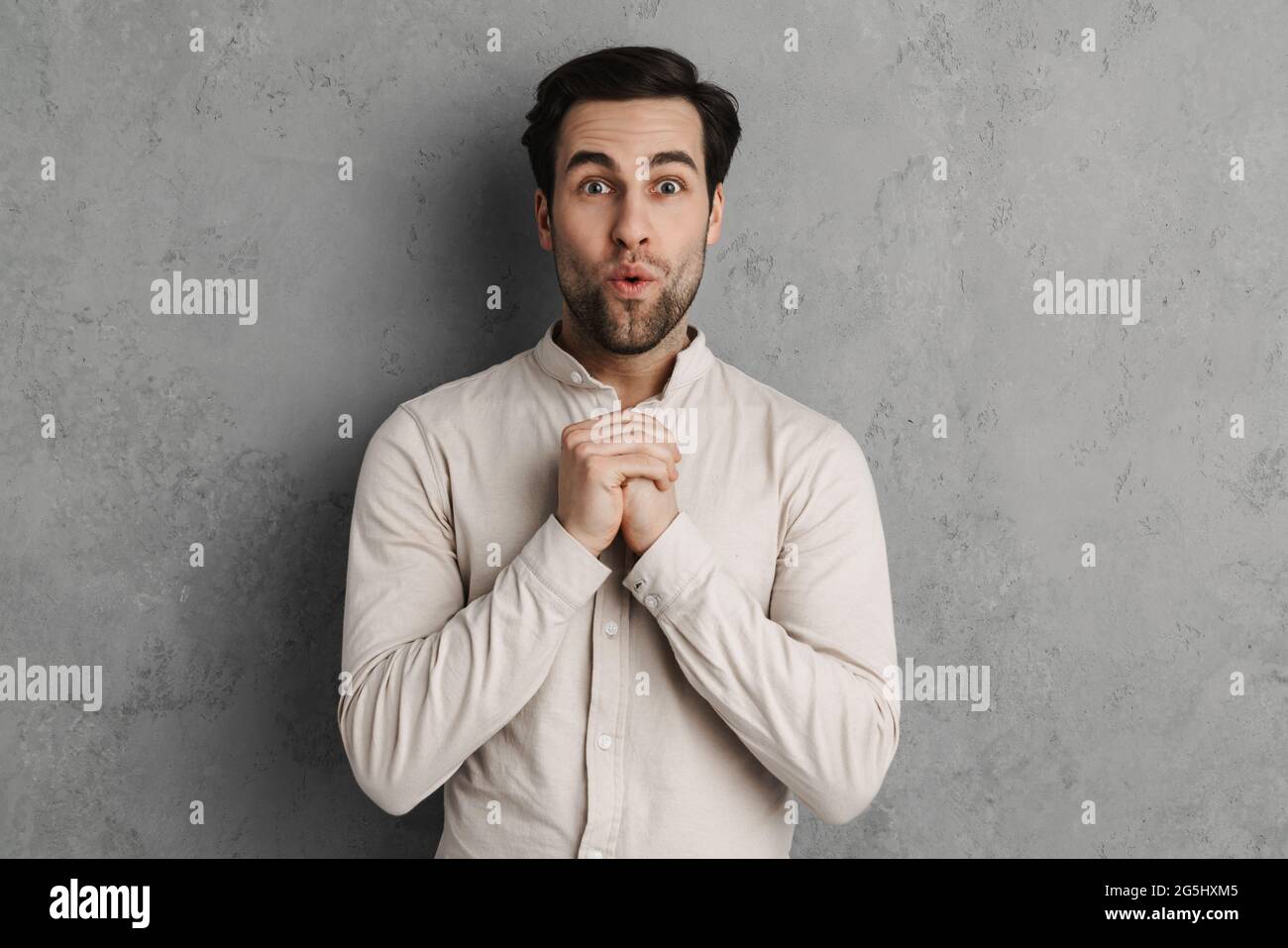 Excited handsome unshaven guy expressing surprise on camera isolated ...