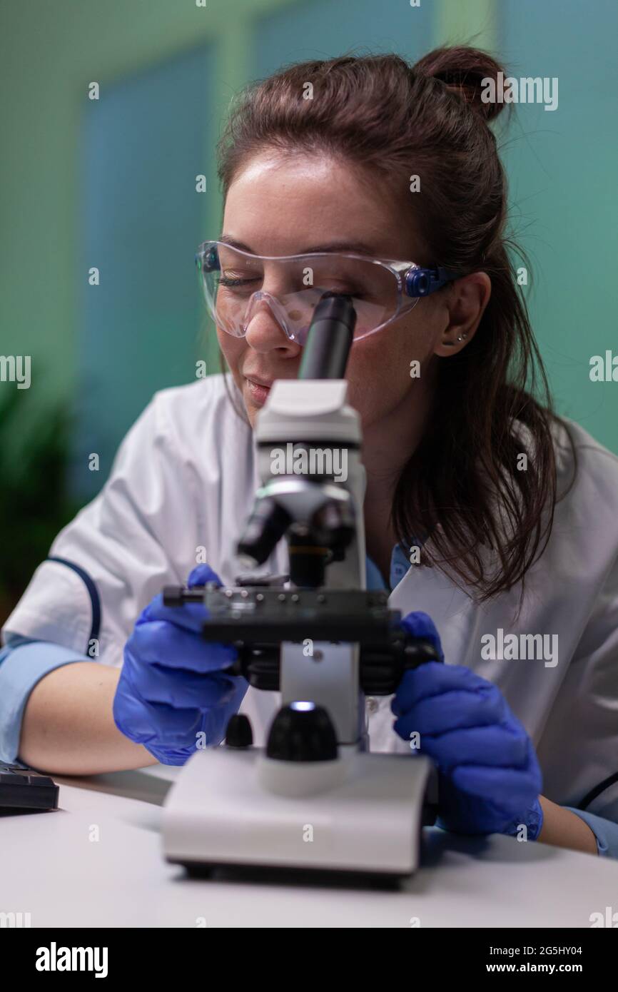 Biochemistry doctor examining chemical test using microscope for ...