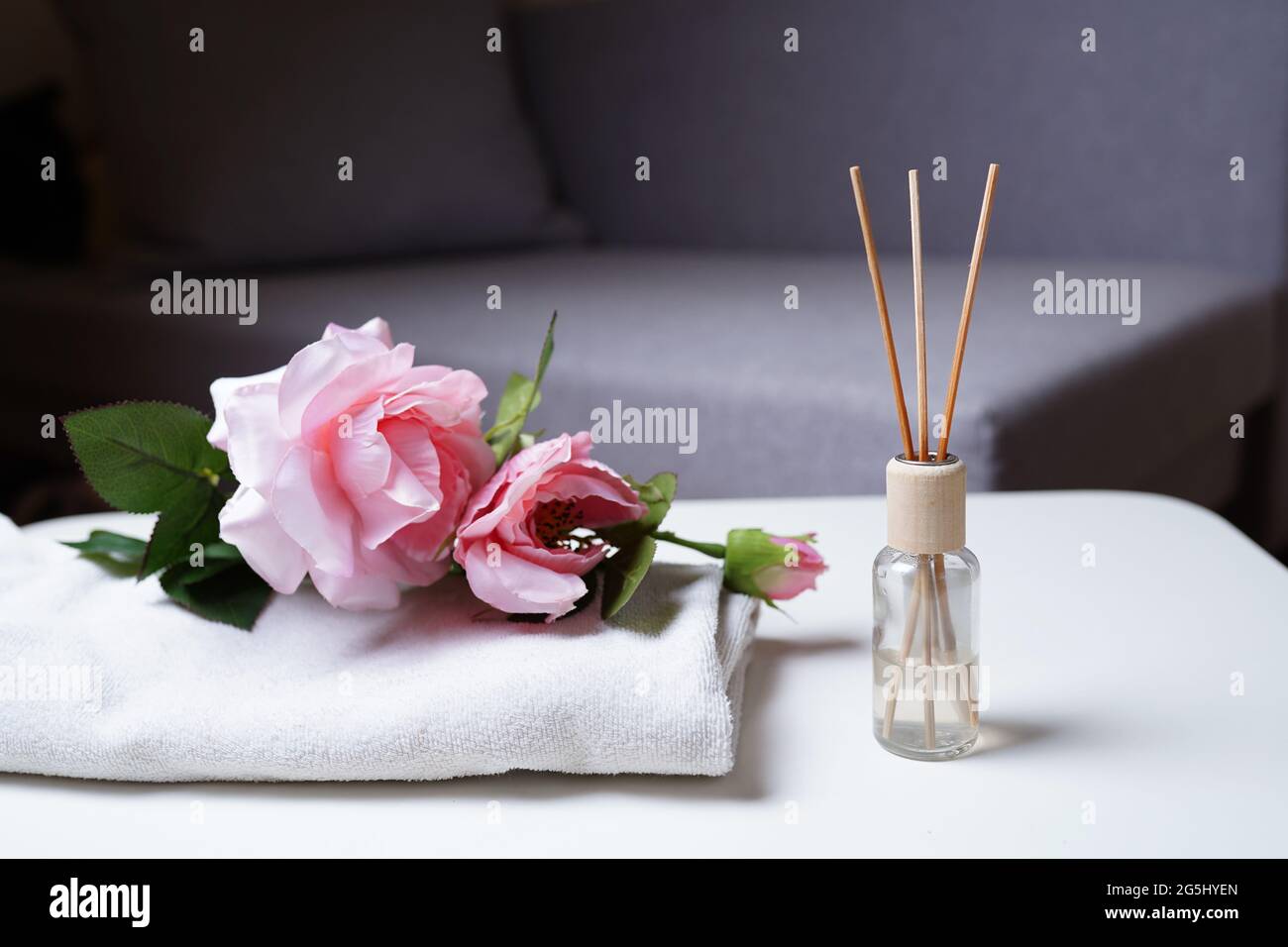 stylish aromatic reed diffuser with pink roses flowers on the white ...