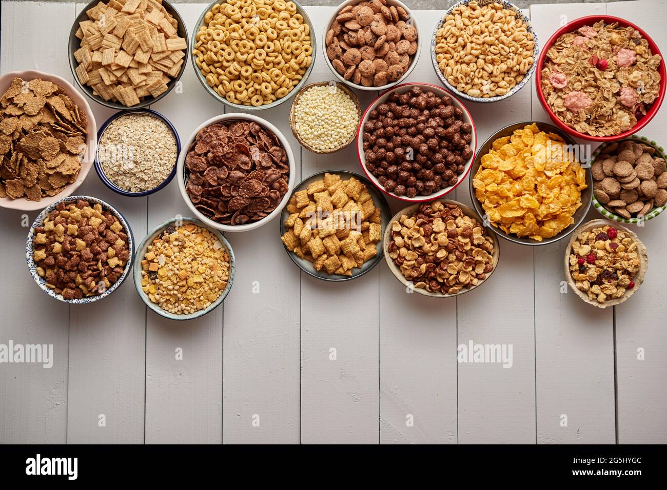 Assortment of different kinds cereals placed in ceramic bowls on table ...