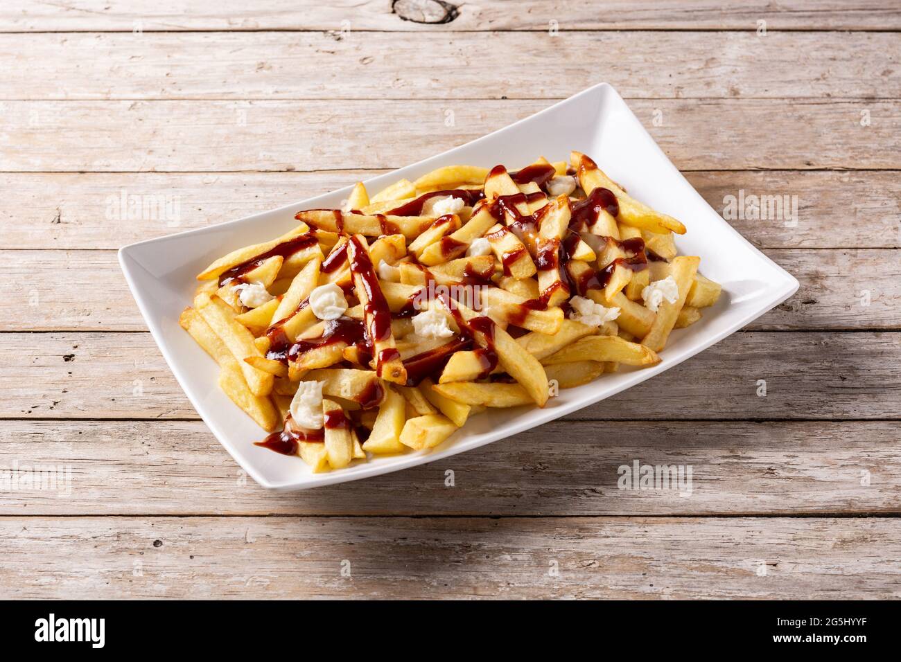 Traditional Canadian Poutine on wooden table Stock Photo - Alamy