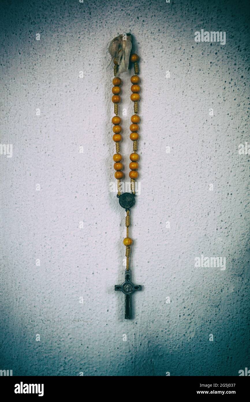 Rosary hanging on the wall with grunge filter and vignetting. Religious ...