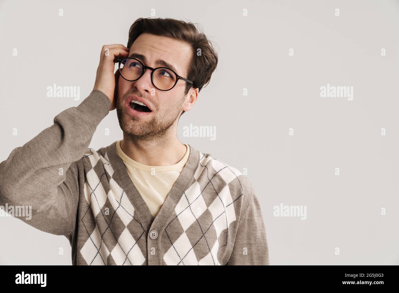 Brooding handsome guy in eyeglasses looking upward isolated over white ...
