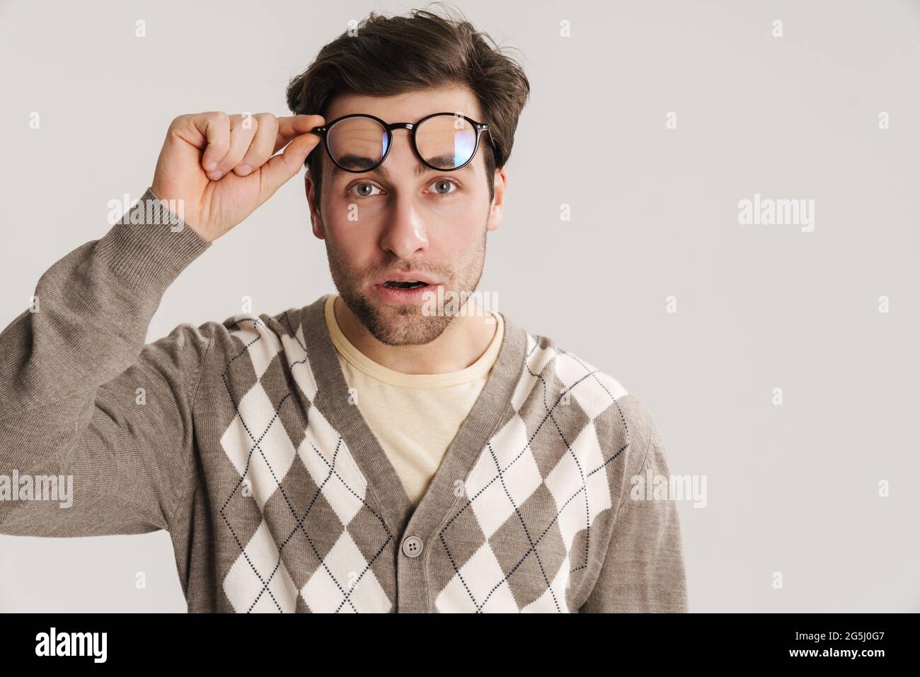 Brooding handsome guy in eyeglasses looking at camera isolated over ...