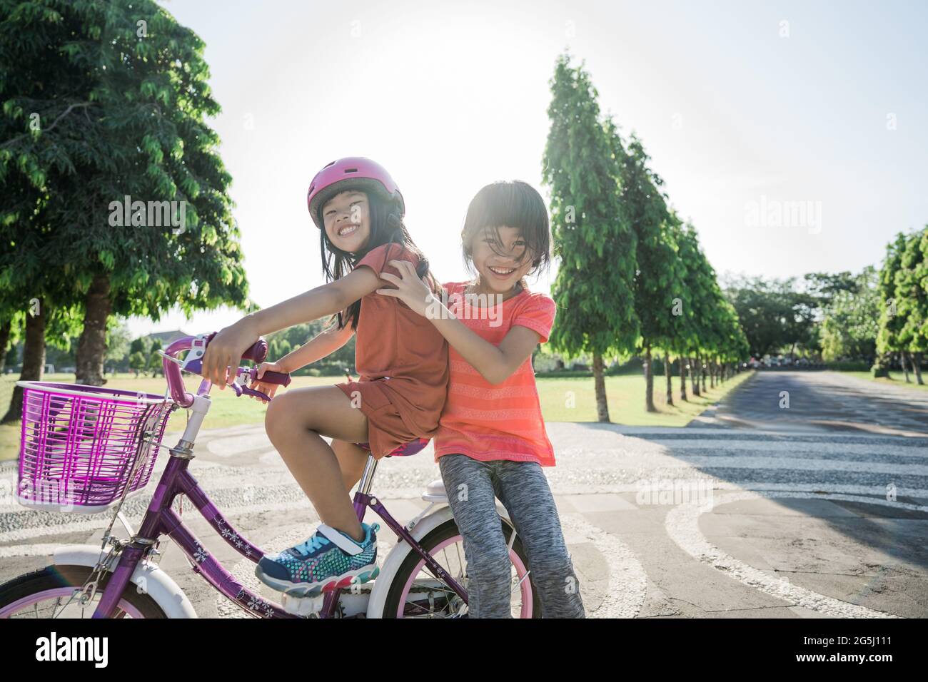 two kids enjoy Ride Bike In the park togethe Stock Photo - Alamy