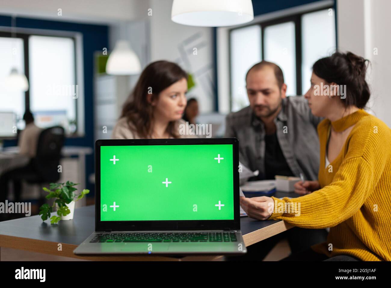 Businesspeople analysing annual financial reports sitting at desk in ...