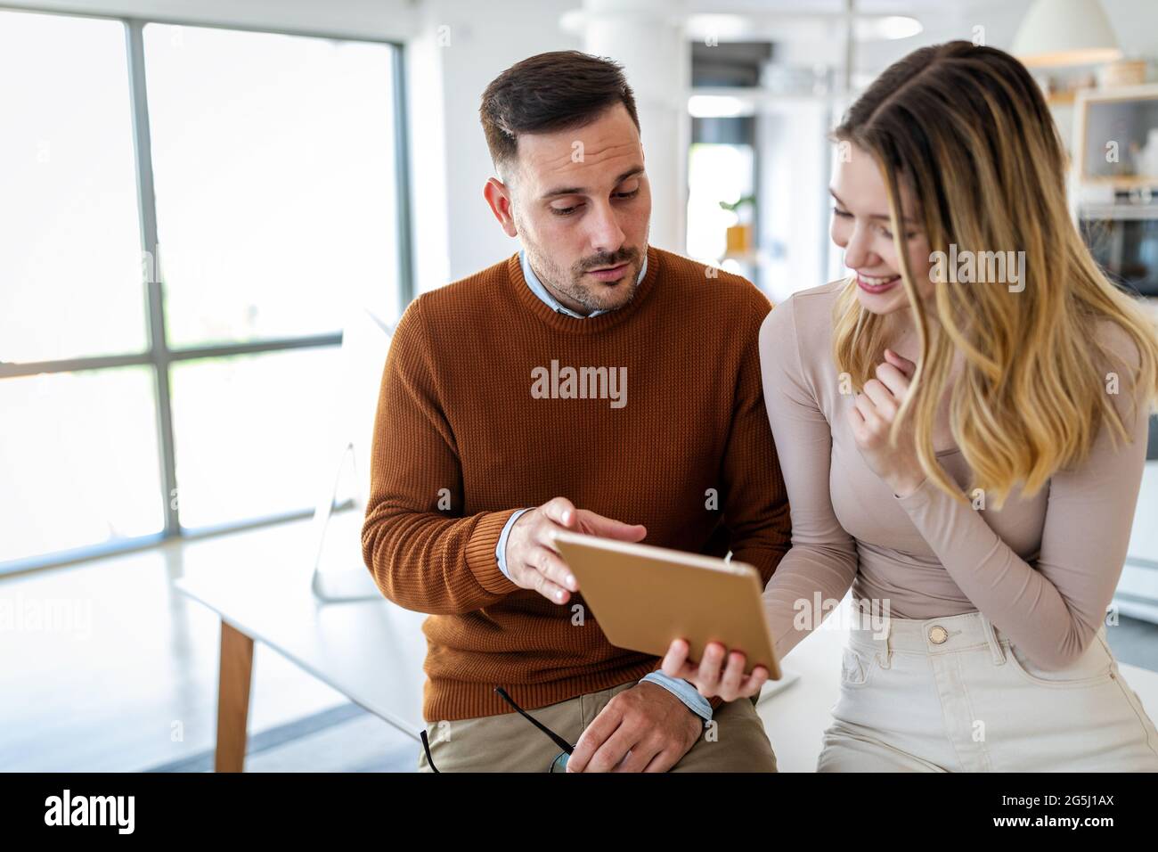 Positive couple having fun while working together remotely at home ...