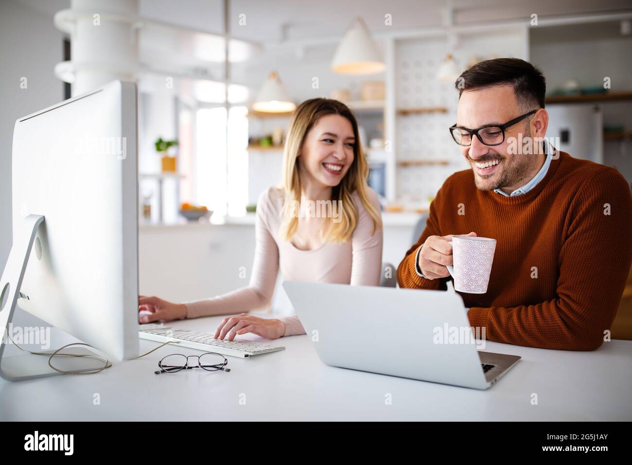 Positive couple having fun while working together remotely at home ...