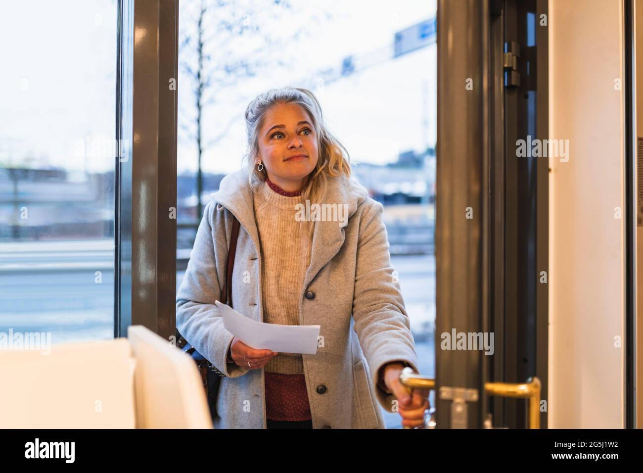 Woman entering retail store Stock Photo - Alamy