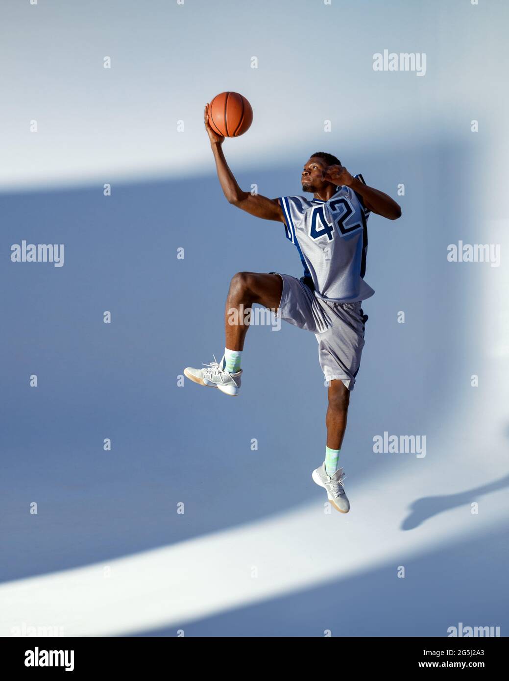 Basketball player with ball, high jump in action Stock Photo - Alamy