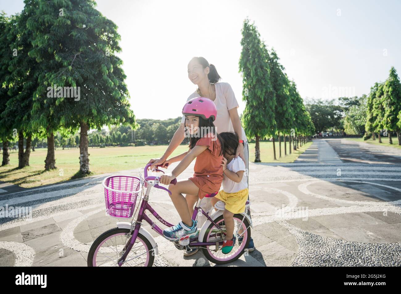 Mom teaching bicycle daughter hi-res stock photography and images - Alamy