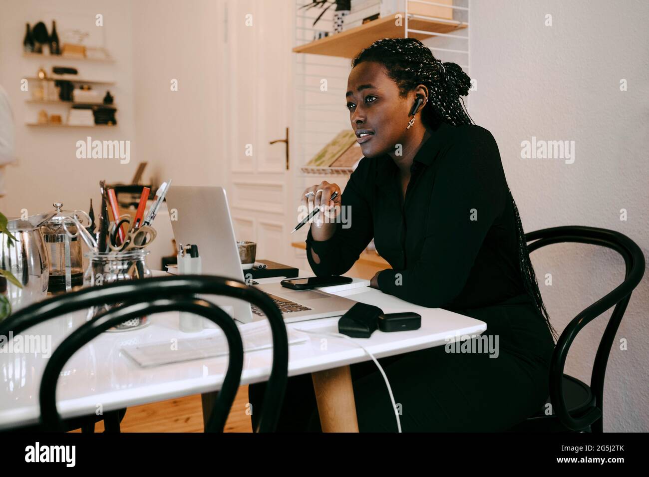 Female entrepreneur sitting with laptop working in home office Stock ...