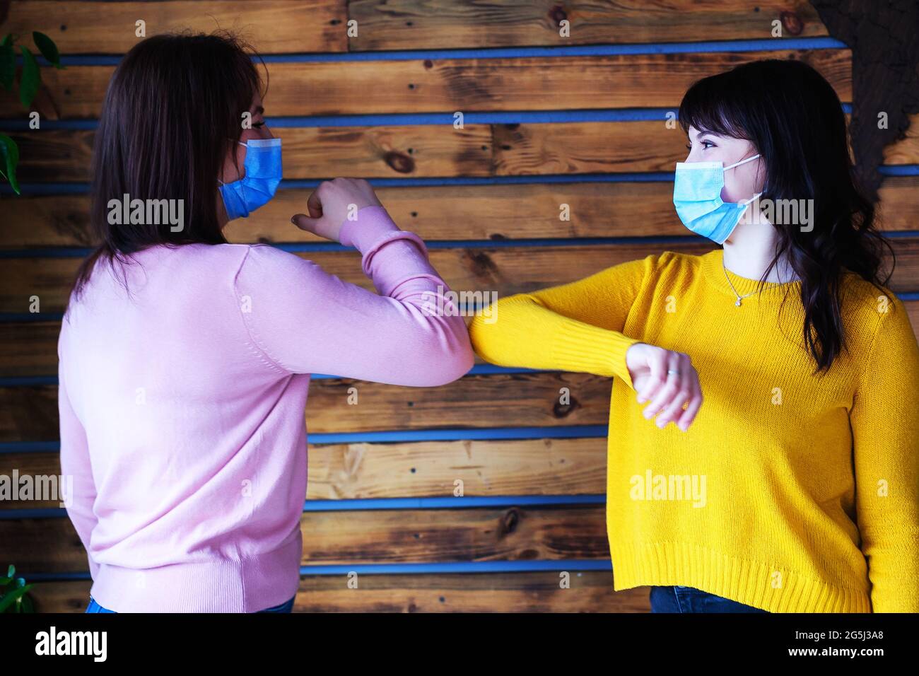 Girls greet, touching with their elbows - Instead of shaking hands ...