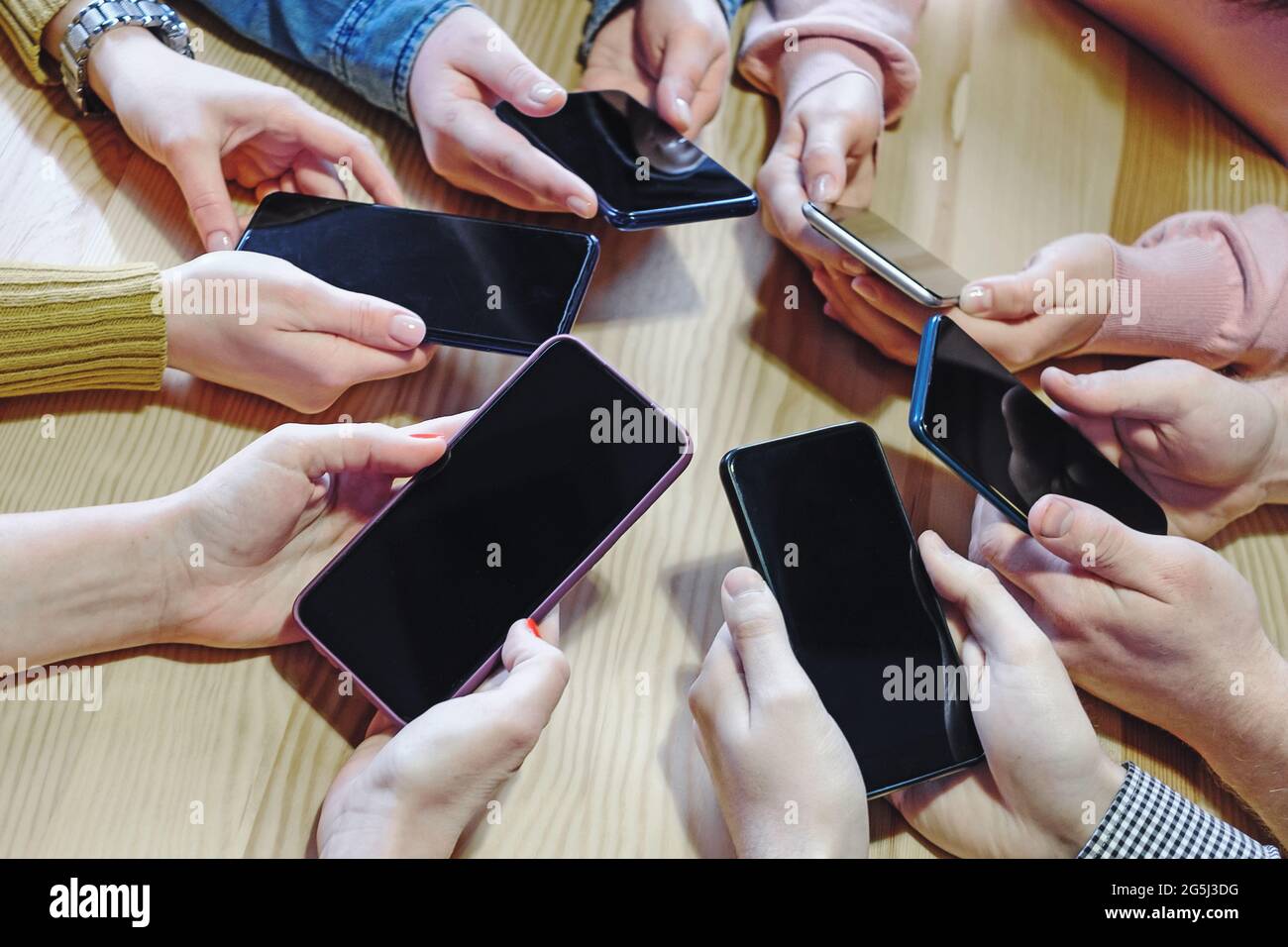 A group of millennials holding mobile phones in their hands ...