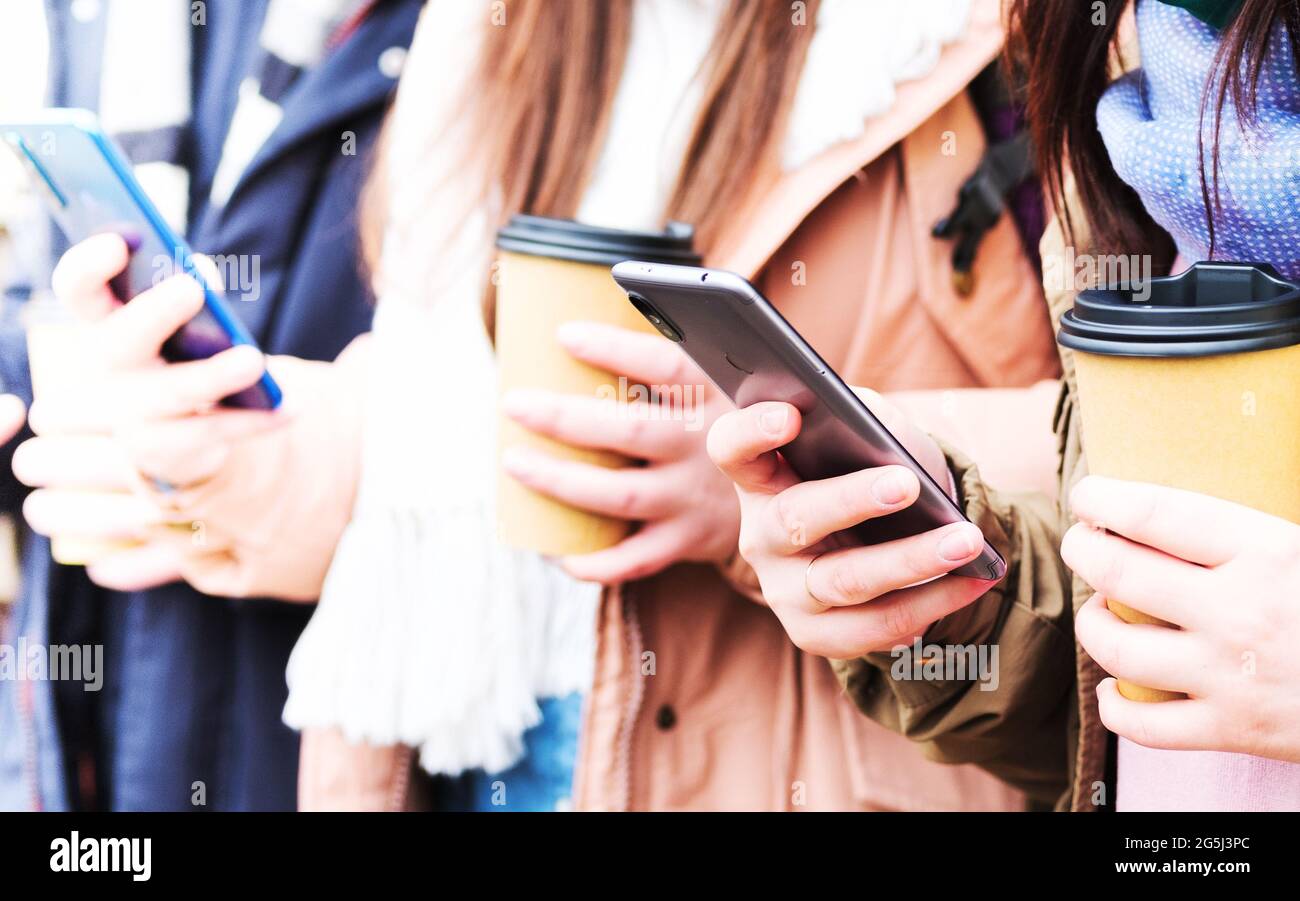 A group of friends surfing the internet with a mobile phone ...