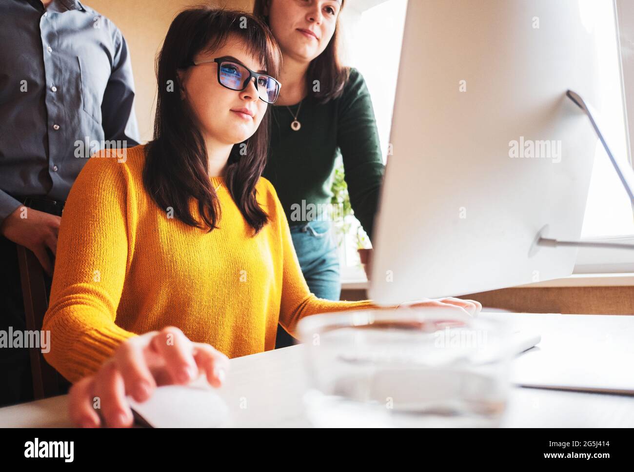 Employees in the office use a computer for a new project - Teamwork in ...