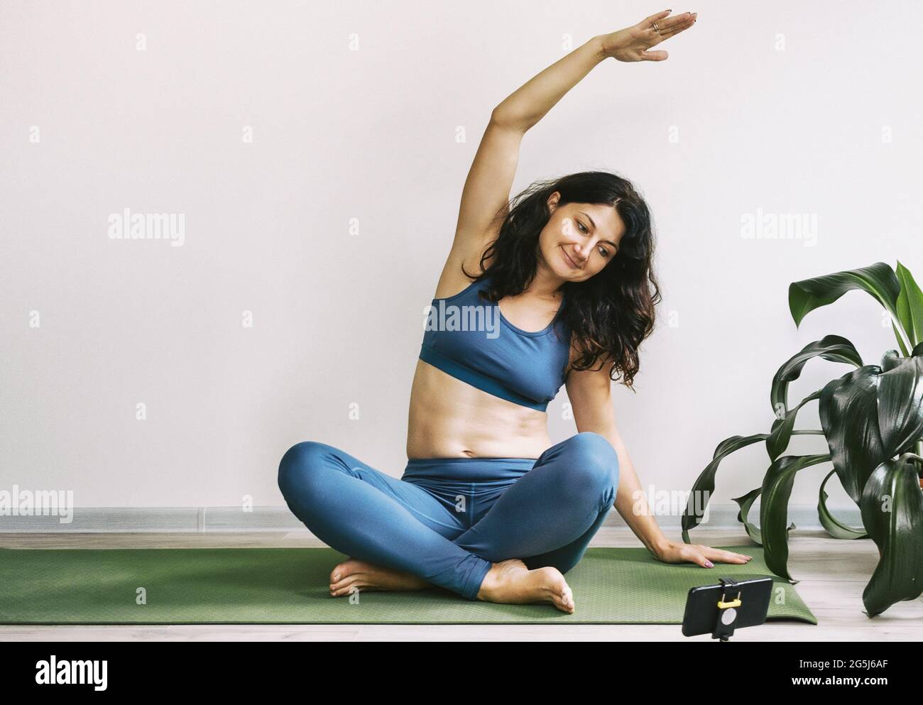 Young girl doing workout at home - Woman repeating sports exercises ...