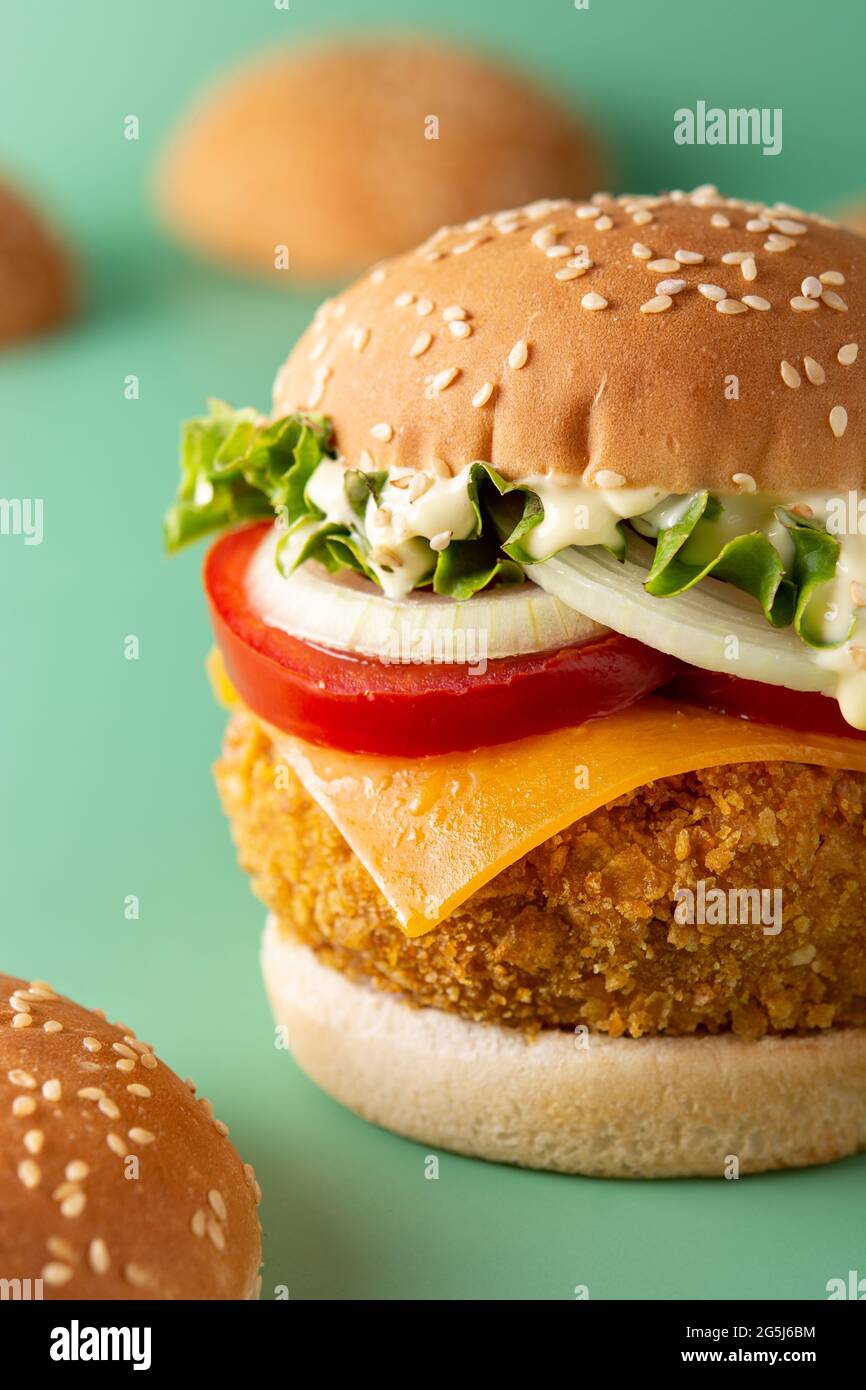 Crispy chicken burger on green background Stock Photo - Alamy