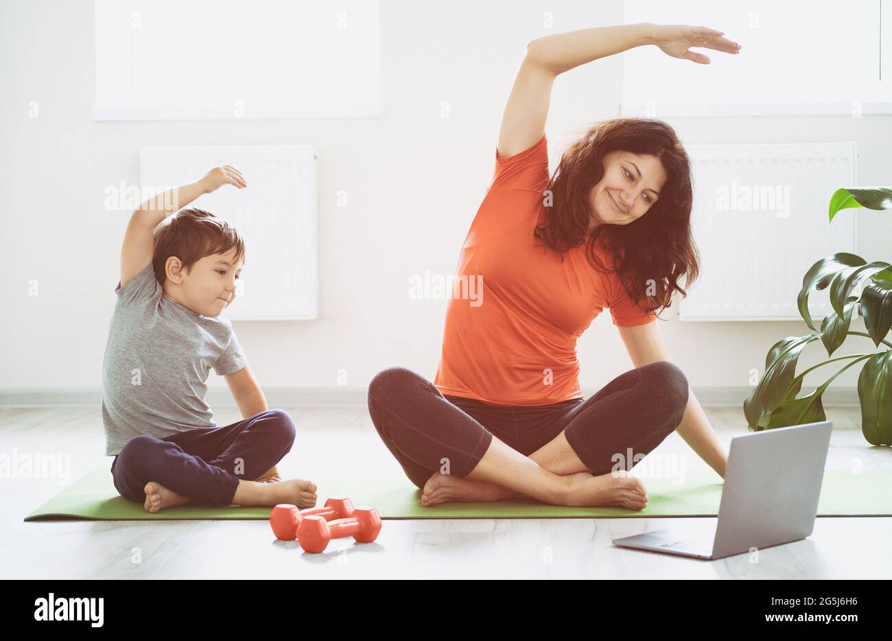 Mom and little son doing workout at home in the room - Online workout ...