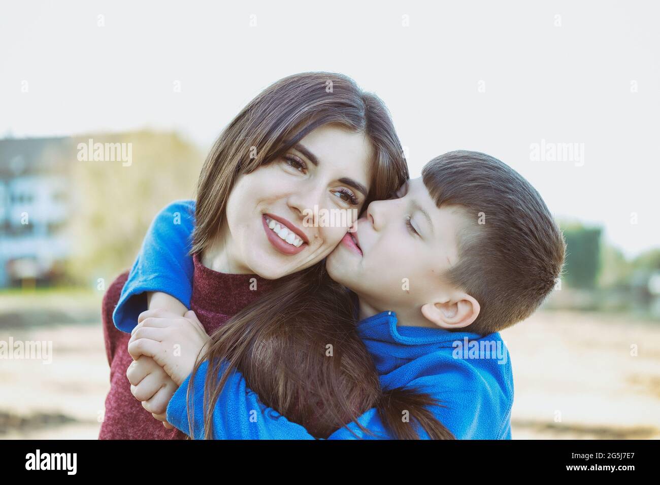 Son hugs mom and have fun - son kisses mom and play outdoors - mom and ...