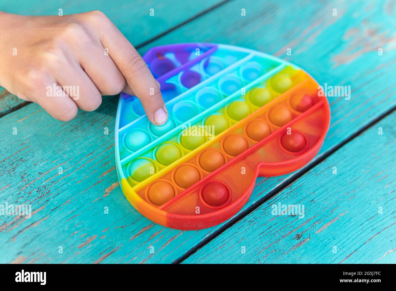 colorful antistress sensory toy fidget push pop it in kid's hands. The ...