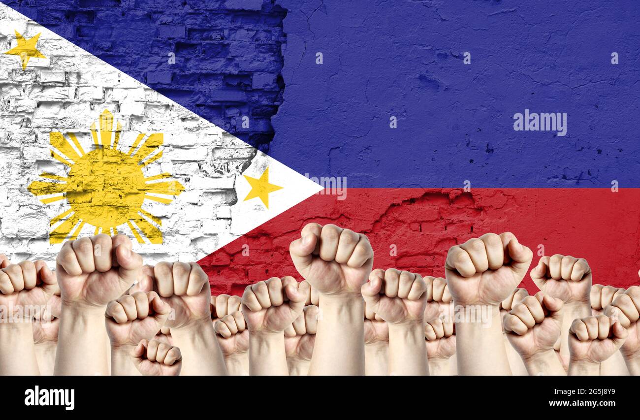 Raised fists of men against the background of the flag of Philippines ...