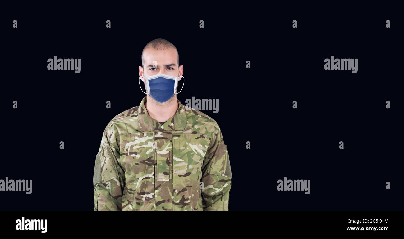 Composition of male soldier wearing face mask, standing to attention ...