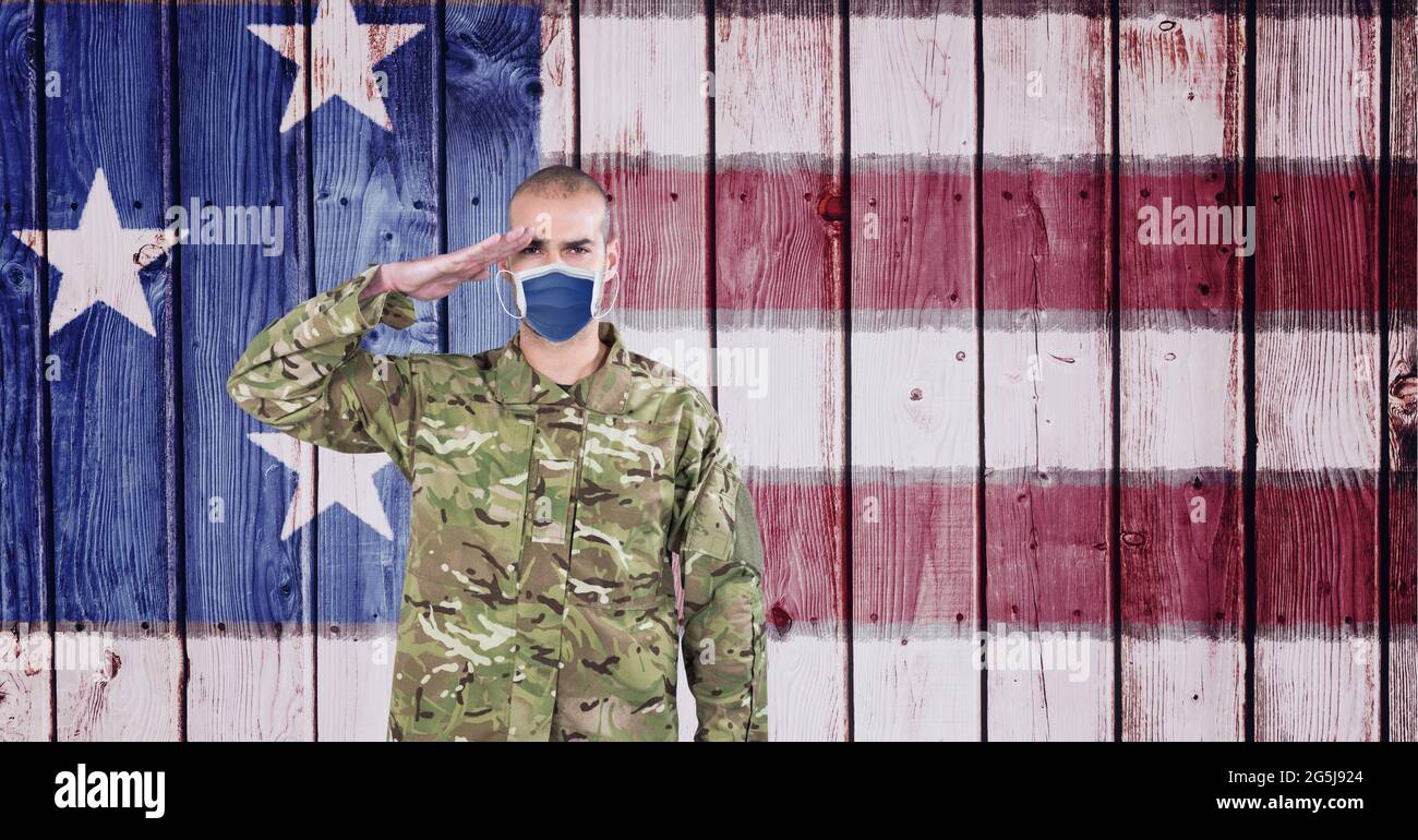 Composition of saluting male soldier wearing face mask, against ...