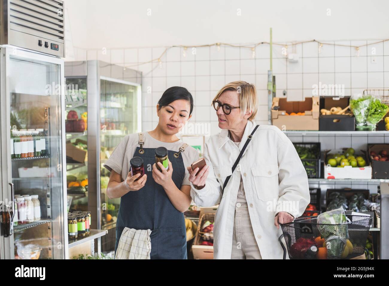 Female owner showing product to customer while buying in store Stock ...