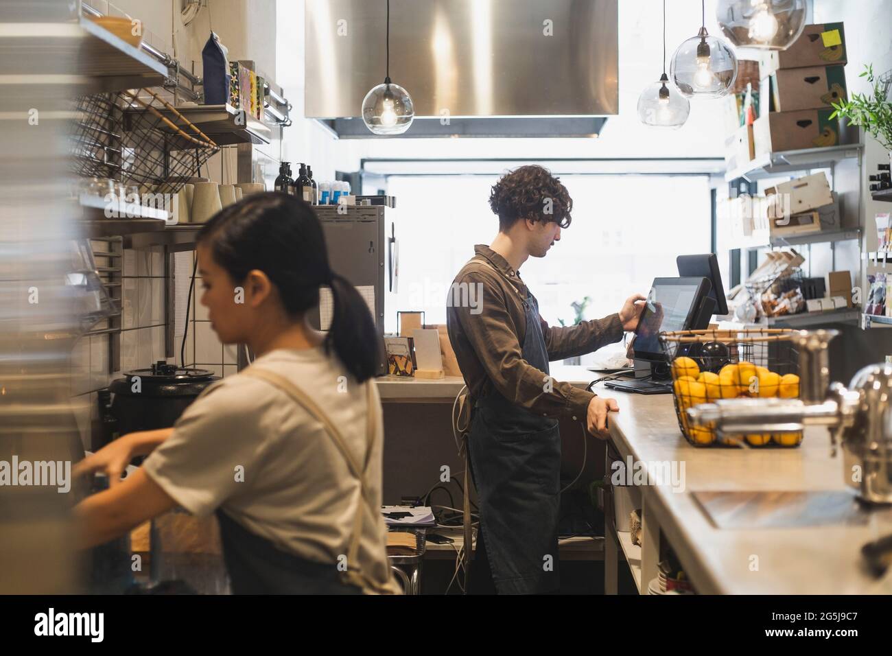 Multi-ethnic male and female entrepreneurs working in store Stock Photo ...