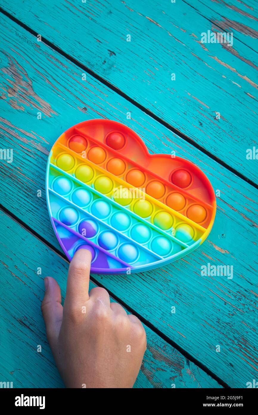 colorful antistress sensory toy fidget push pop it in kid's hands. The ...