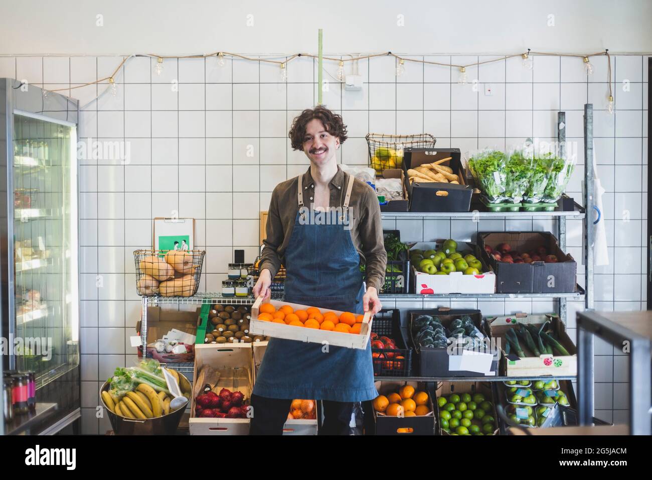 Portrait of smiling male owner with fruit box in store Stock Photo - Alamy