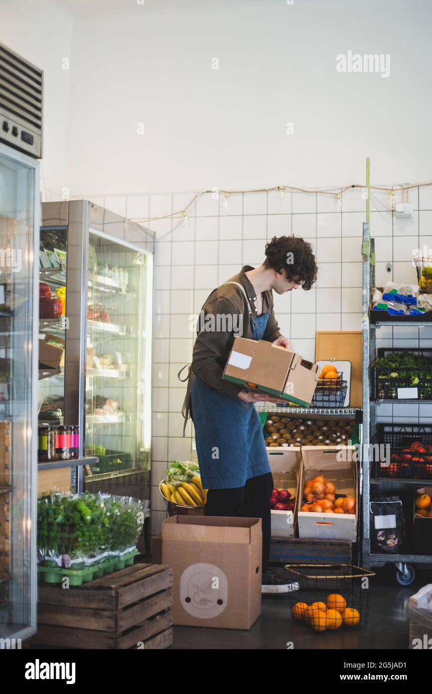 Male owner with fruit box standing in store Stock Photo - Alamy