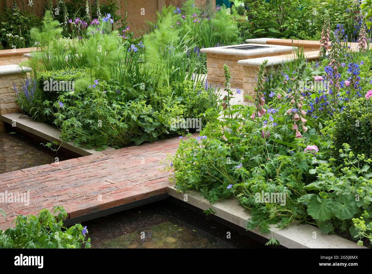 Brick seating area with timber benches and fire pit, pond water feature ...