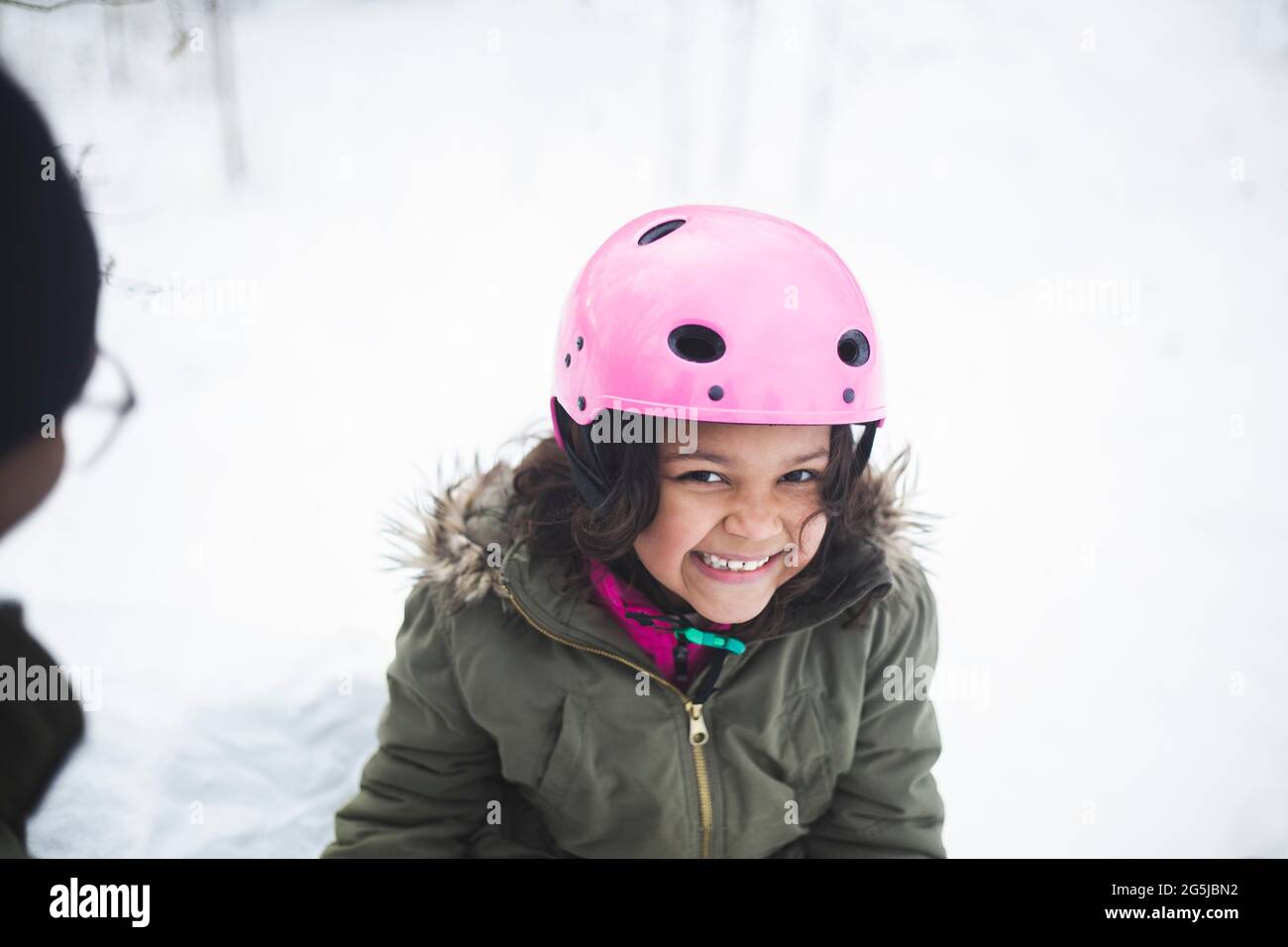 Portrait of cheerful girl wearing pink helmet during winter Stock Photo ...