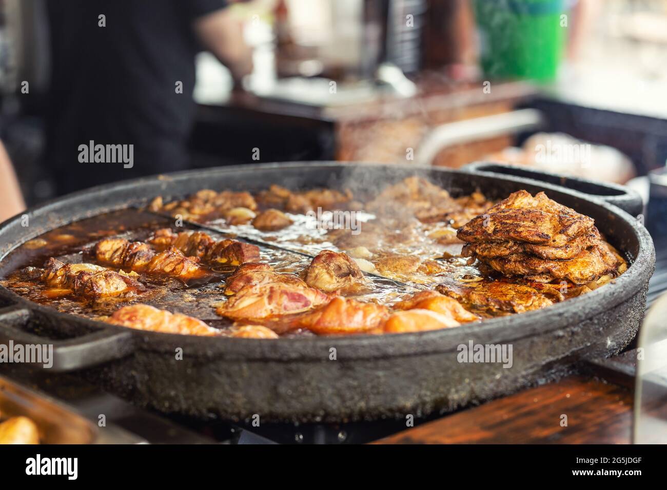 Various assortment of meat fried in a large pan in a restaurant Stock ...