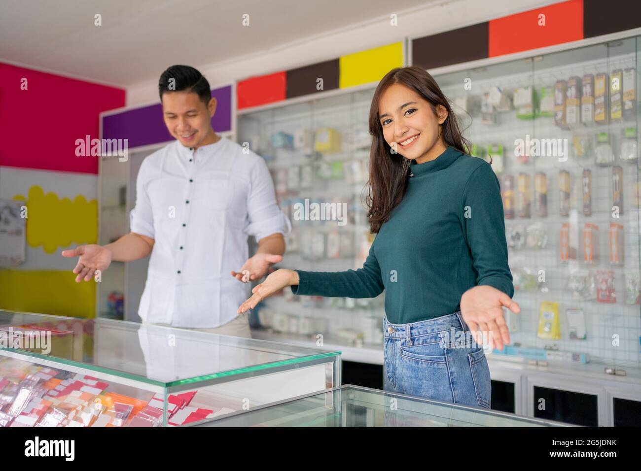 a young man and woman with hand gestures offering something on a ...