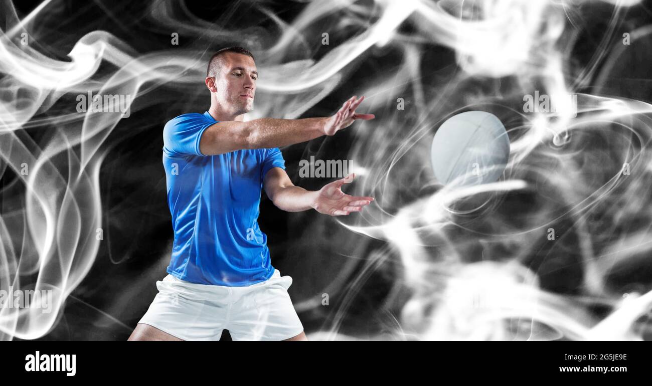 Composition of male rugby player catching rugby ball on black ...