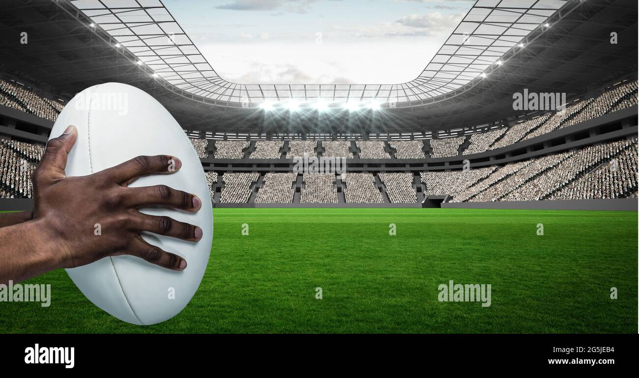 Composition of male rugby player holding ball at stadium Stock Photo ...
