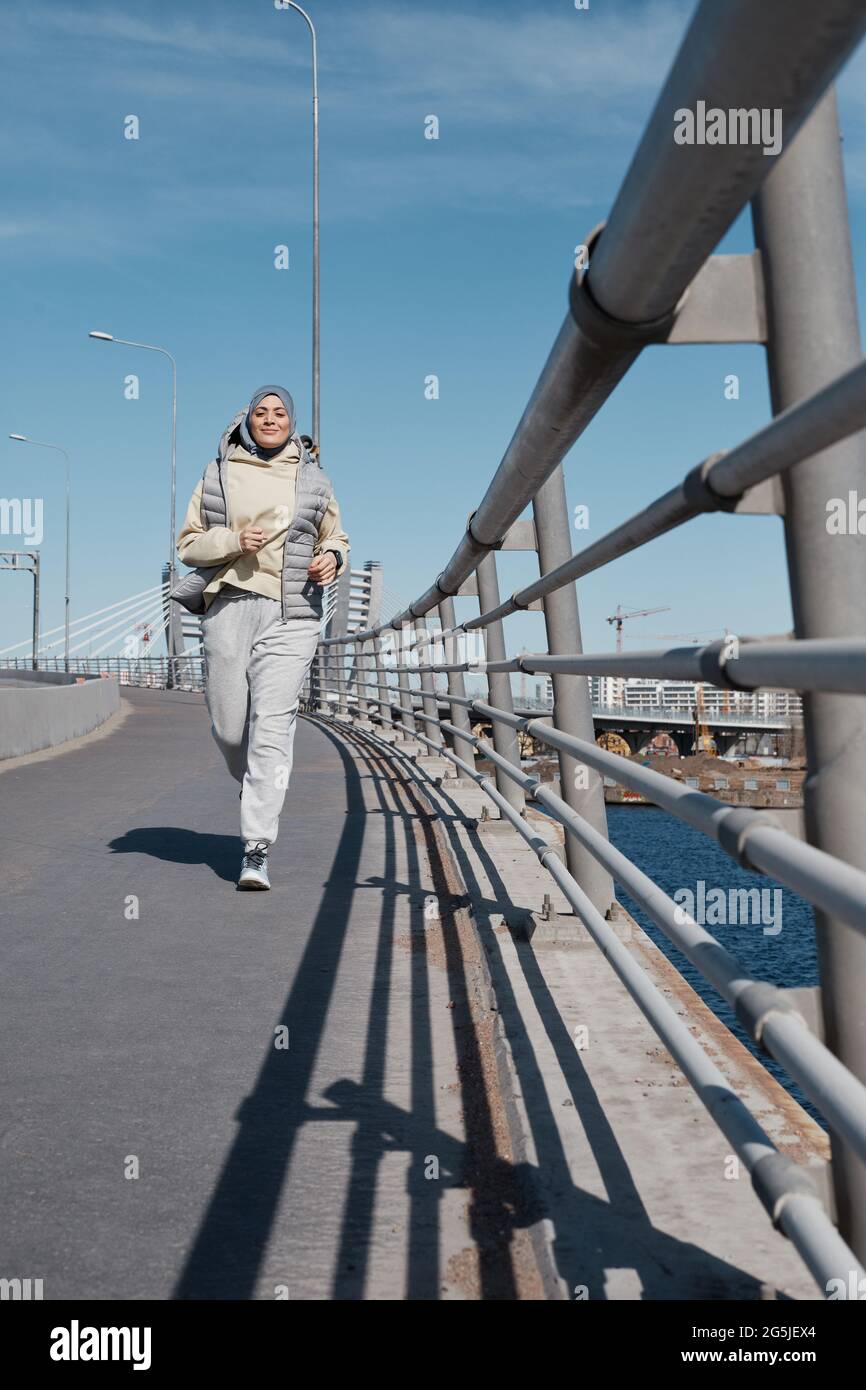 Vertical full length portrait of modern Middle-Eastern woman running ...