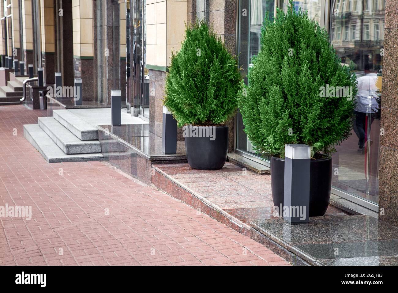 pedestrian walkway made of stone tiles along the building with ...