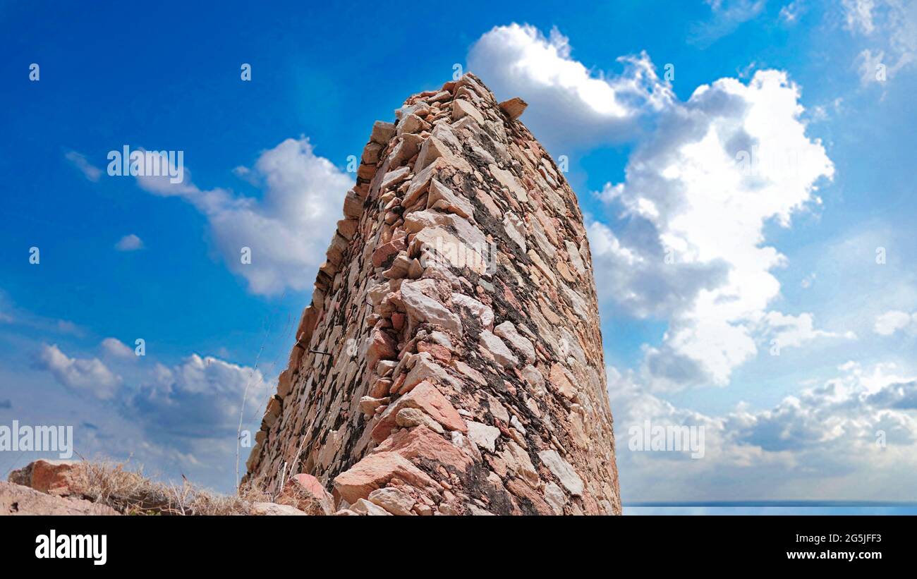 Rough stone column with white blue sky background. Ancient fort with ...
