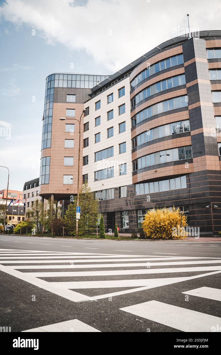 Modern architectural building next to the street with bushes around ...