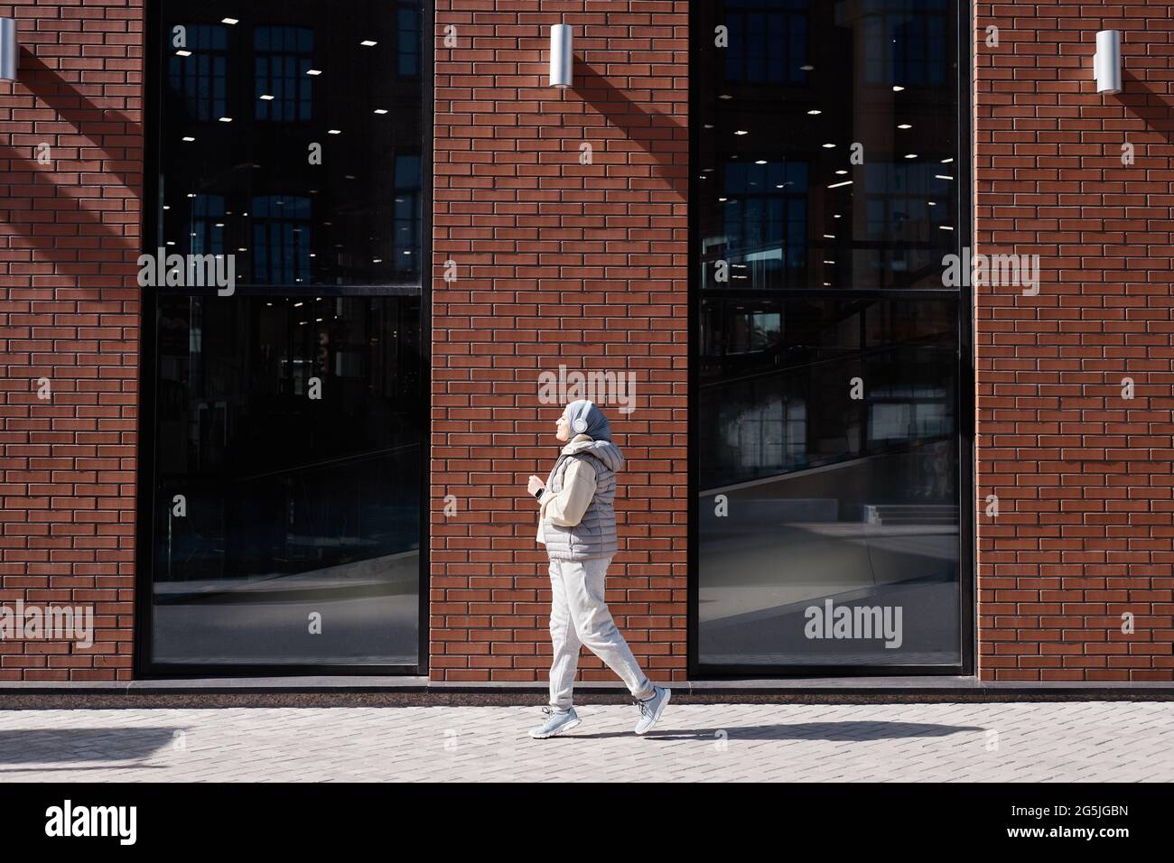 Wide angle side view portrait of modern Middle-Eastern woman running ...