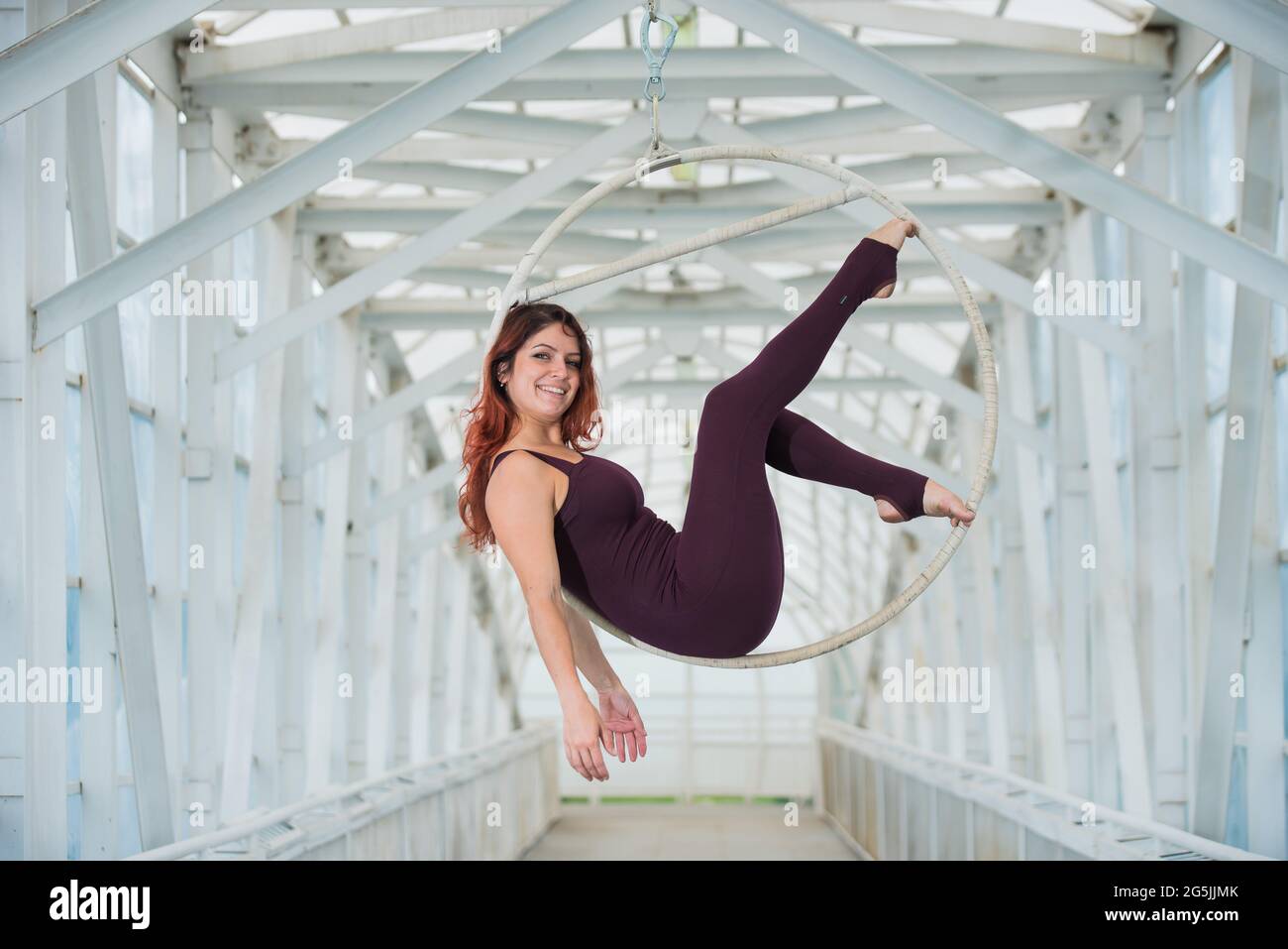 The red-haired aerial gymnast in a sports combo performs at the air ...
