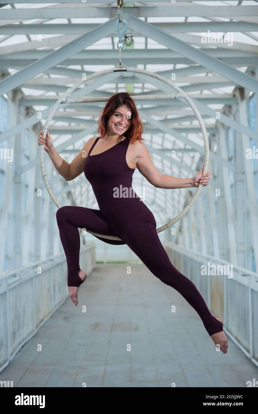 The red-haired aerial gymnast in a sports combo performs at the air ...